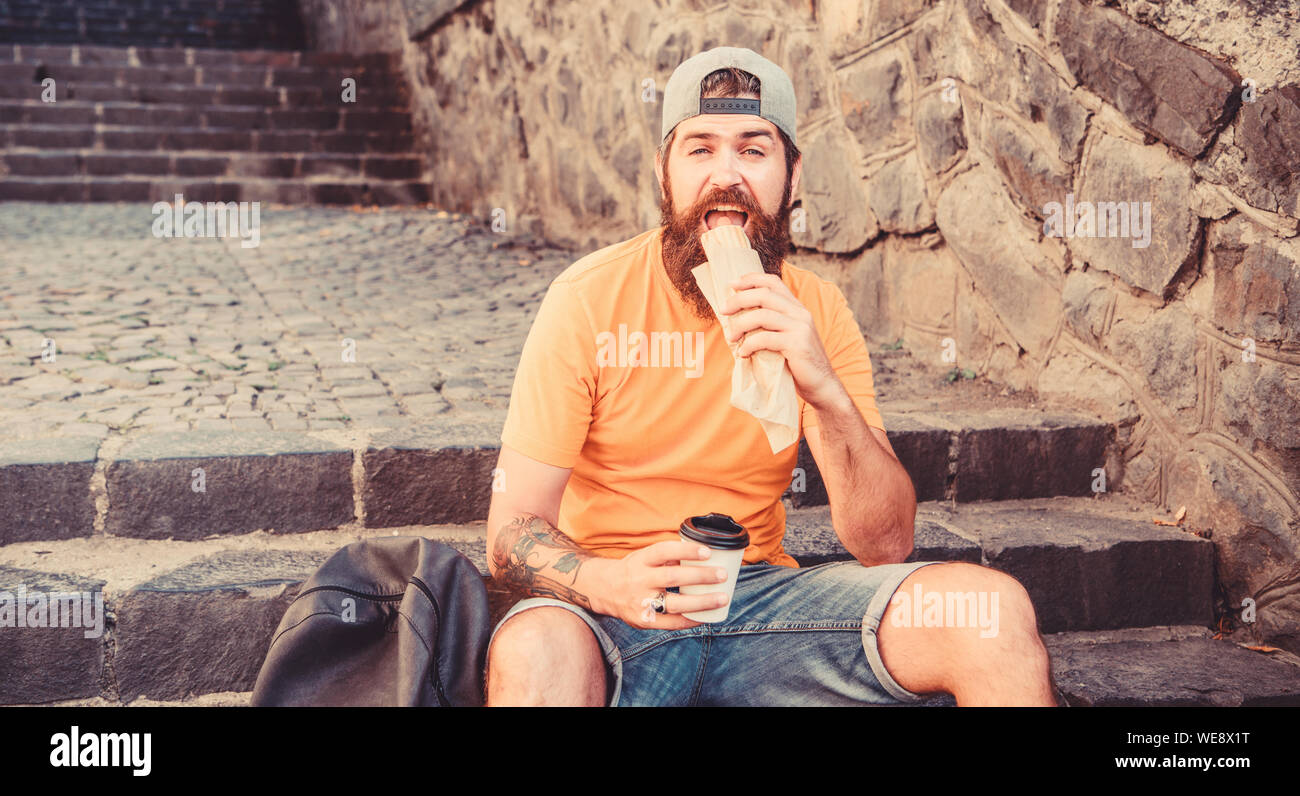 Man bearded enjoy quick snack and drink paper cup. Street food so good ...