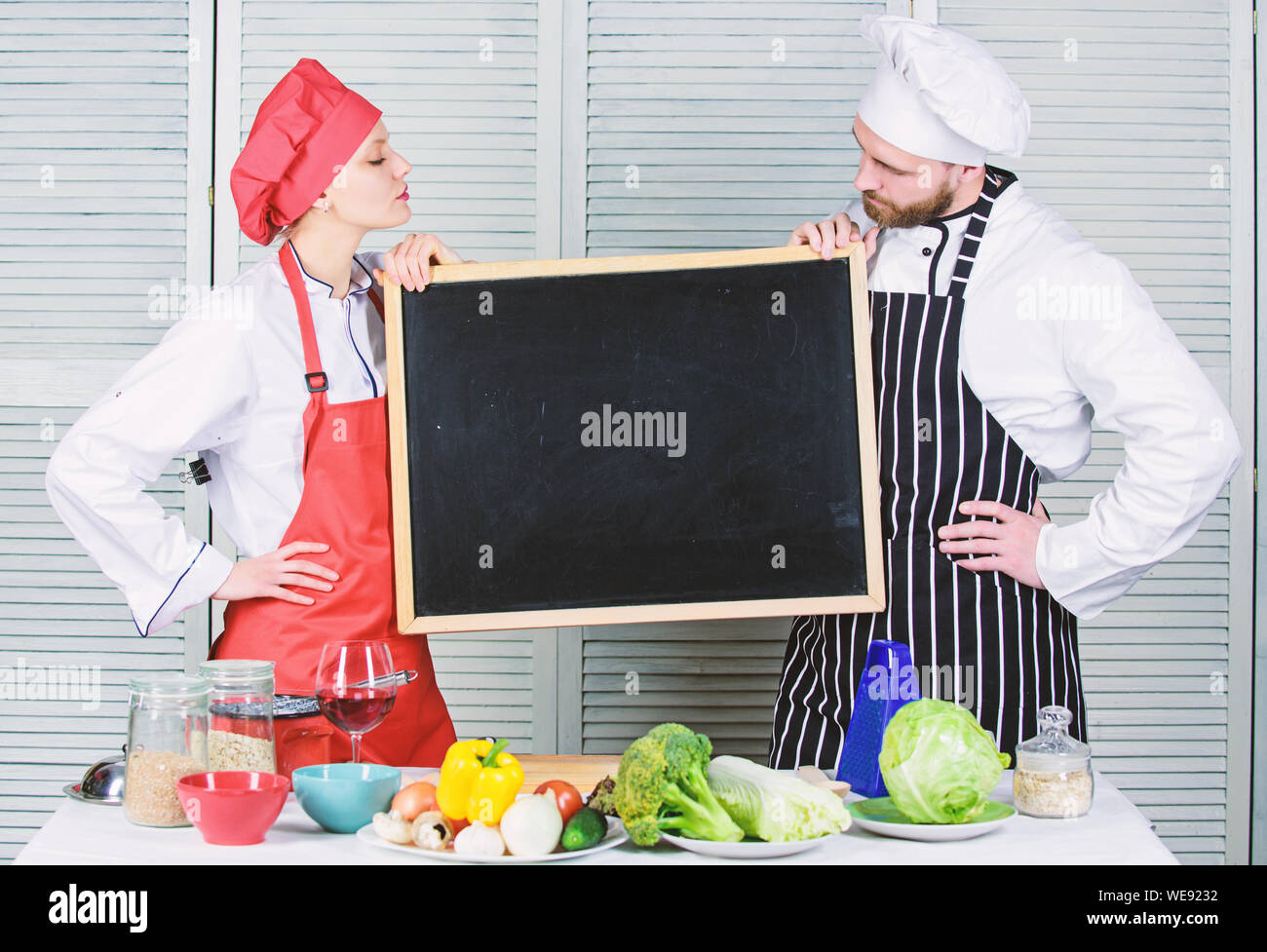 Teaching different cooking techniques. Couple of man and woman holding ...