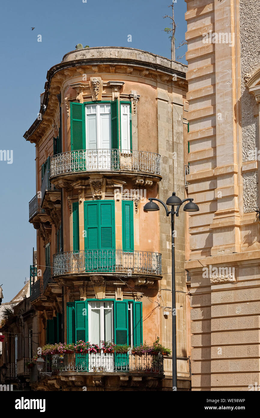 old corner building, rounded, ornate, green shutters, iron balconies ...