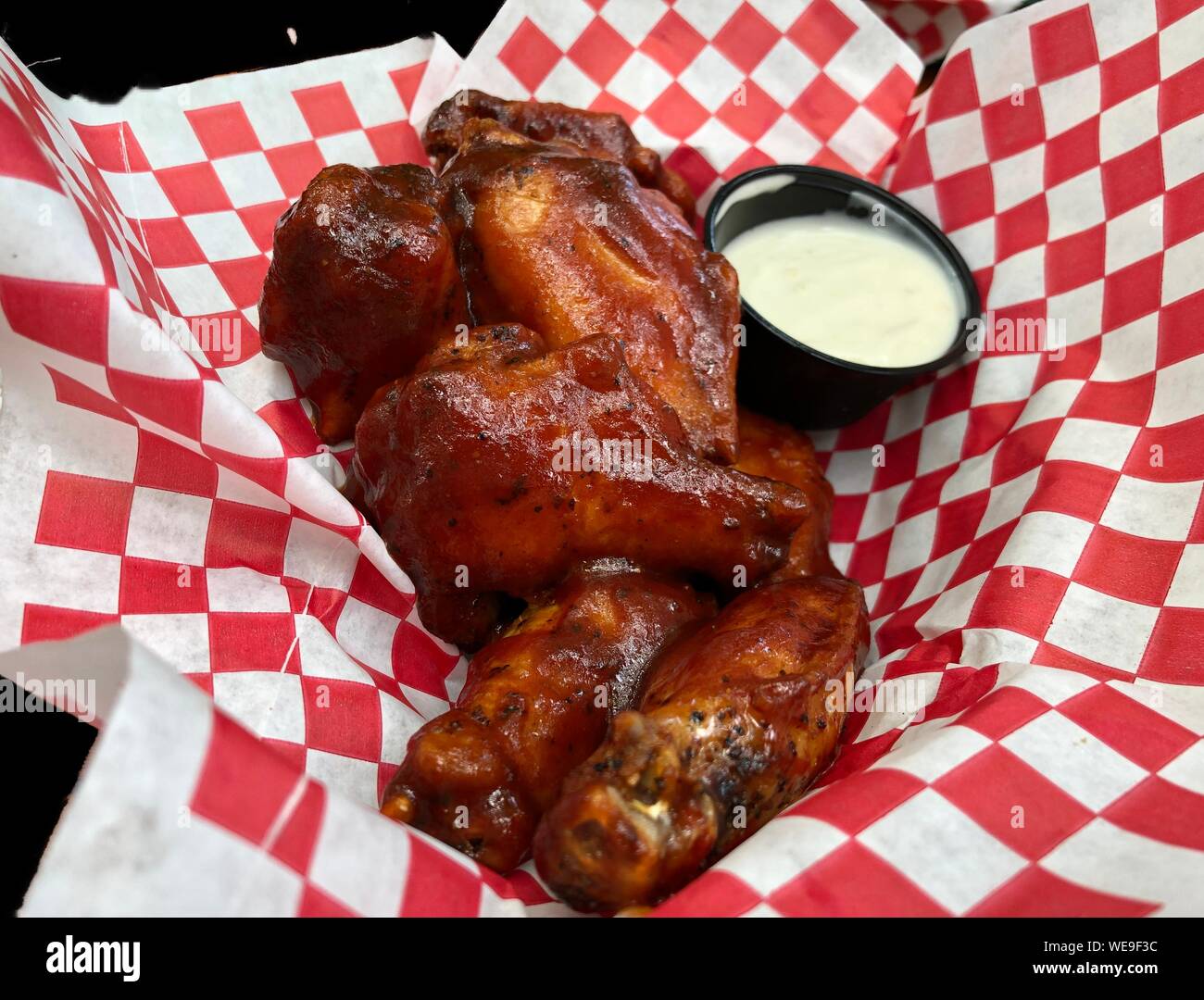 Medium close up of chicken wings barbeque with a small dish of tartar ...