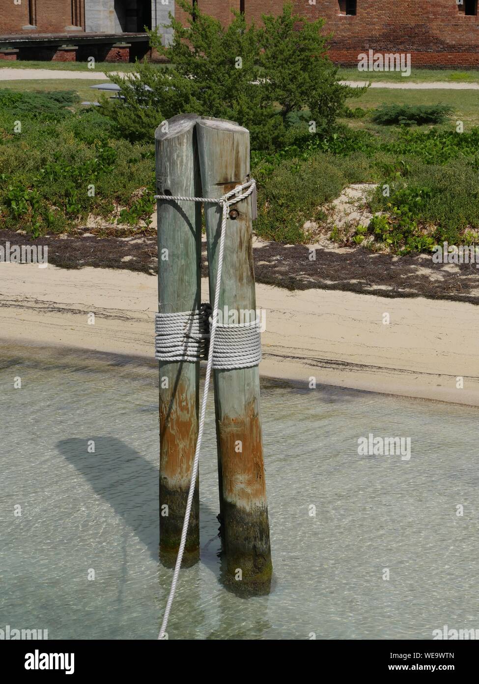 Nautical ropes tied around two poles at a dock Stock Photo - Alamy