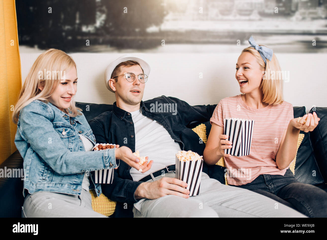 Happy friends relaxing sitting on couch and watching championship or ...