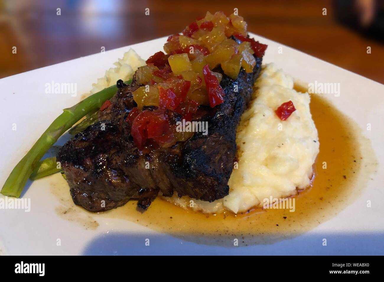 Big juicy slab of New York steak with asparagus and potato salad Stock ...