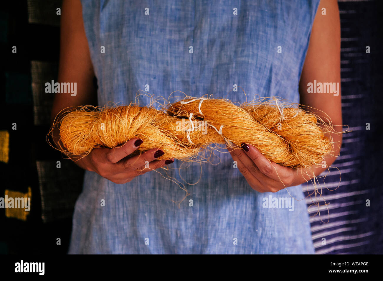 Woamn hands holding natural yellow silk thread fiber. Raw material of ...