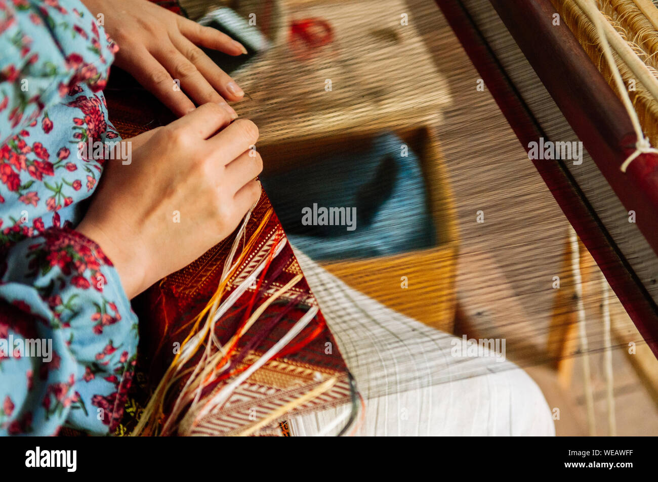Young woman hands working on Vintage wooden weaving loom with silk ...