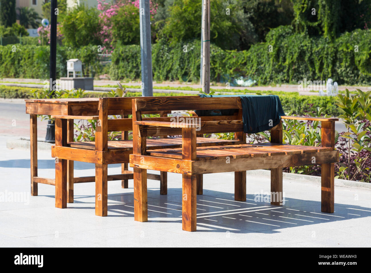 Two benches and a table stand on a pedestrian walkway Stock Photo - Alamy
