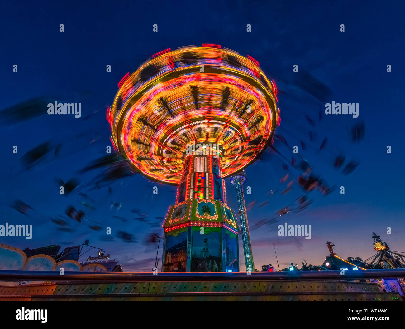 A rotation chain carousel illuminated with different bright colors ...