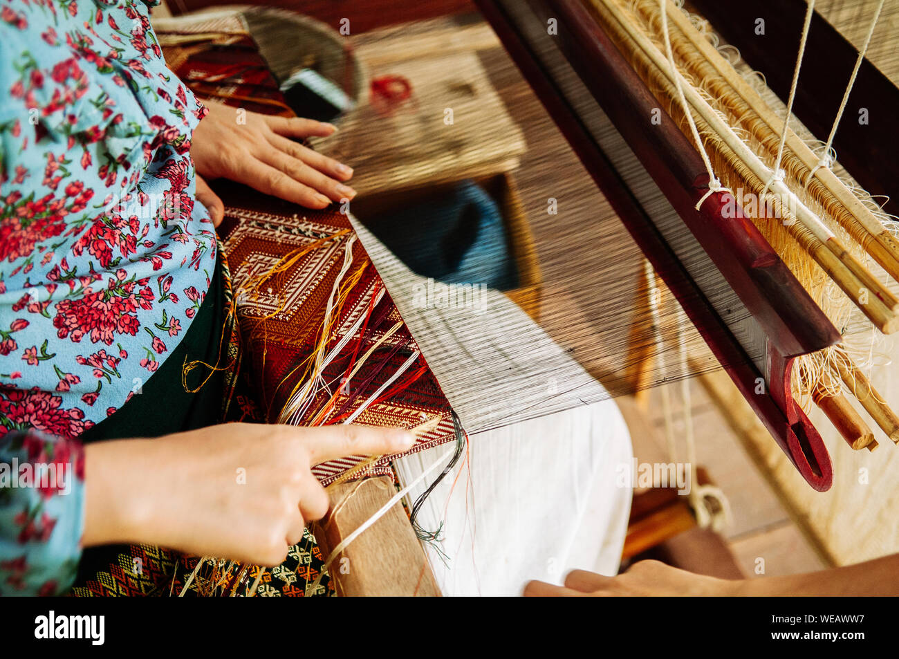 Young woman hands working on Vintage wooden weaving loom with silk ...