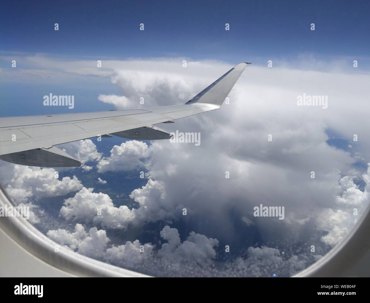 Storm clouds seen from an airplane window, with an airplane wing in ...