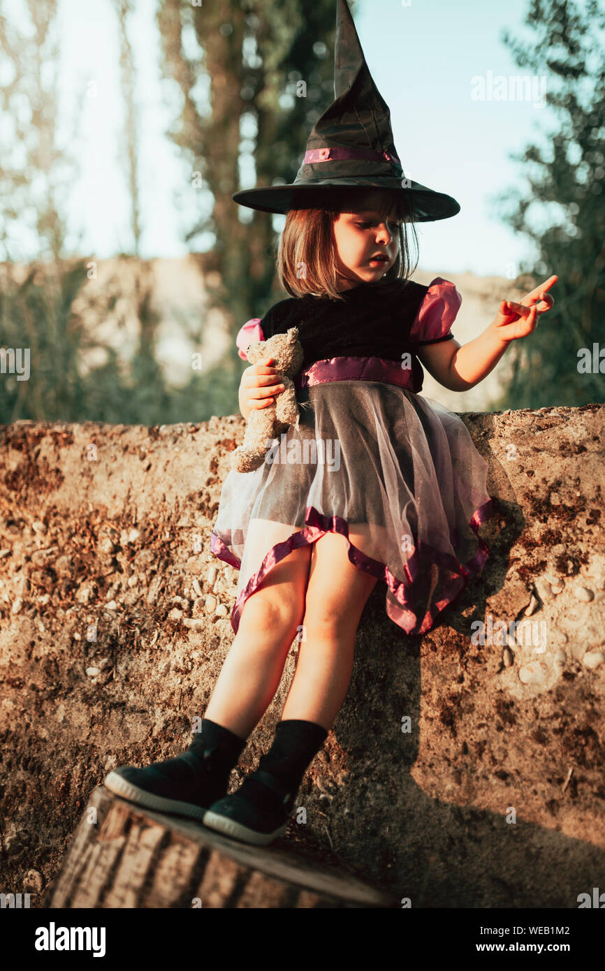 Girl standing disguised as a witch in the woods during Halloween Stock ...