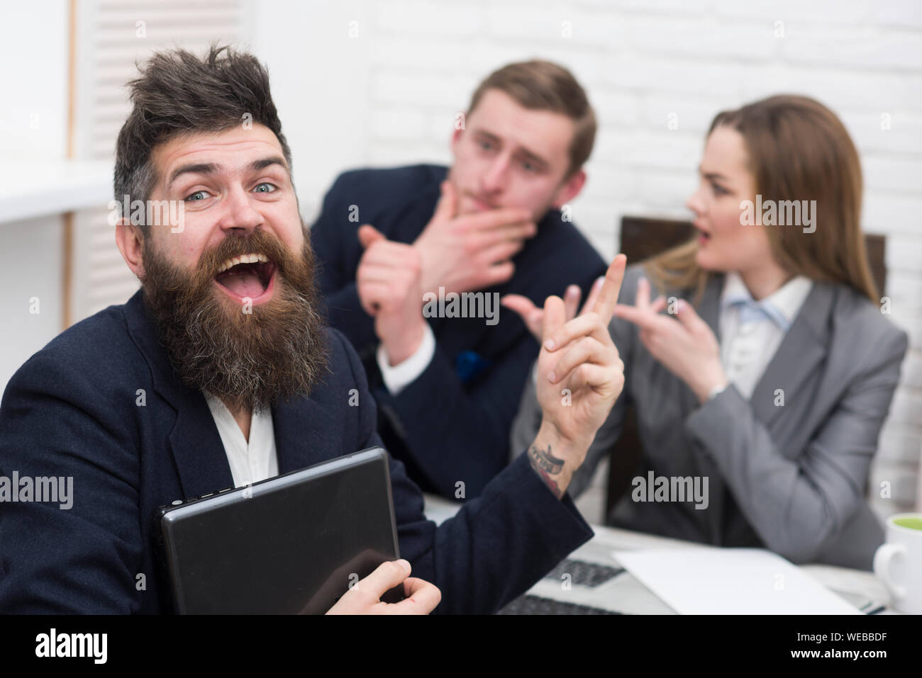 Man with beard on happy face holds laptop, bosses, coworkers ...