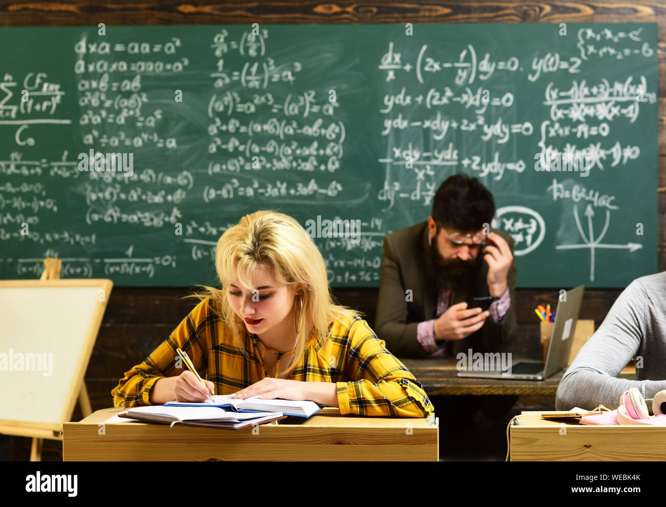Teacher in glasses reading reports of talented students correcting ...