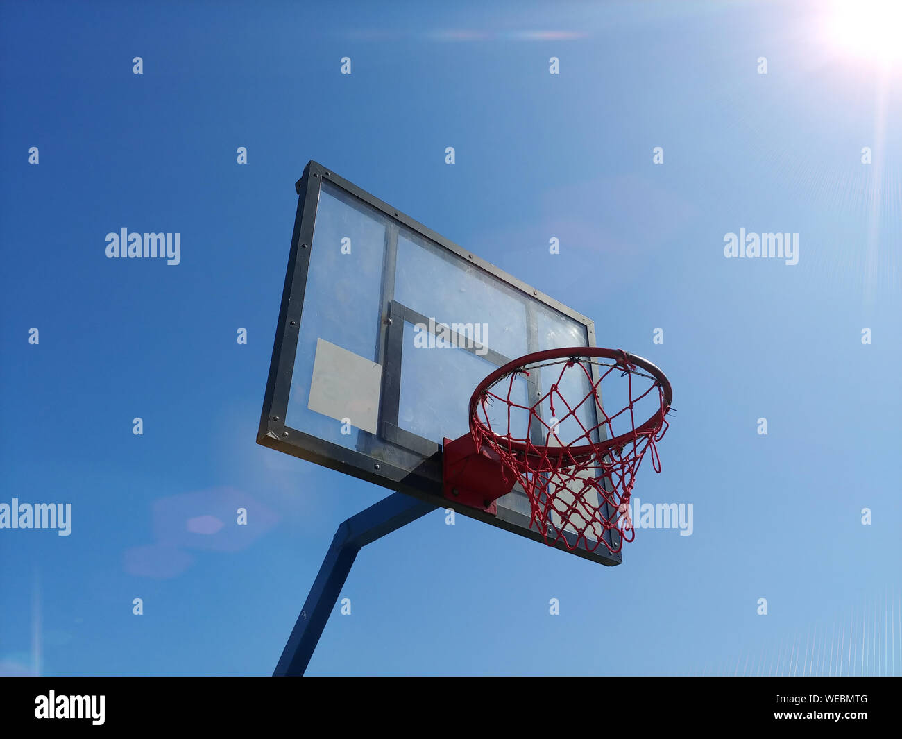side view of basketball ring basket outdoor with clear blue sky on ...
