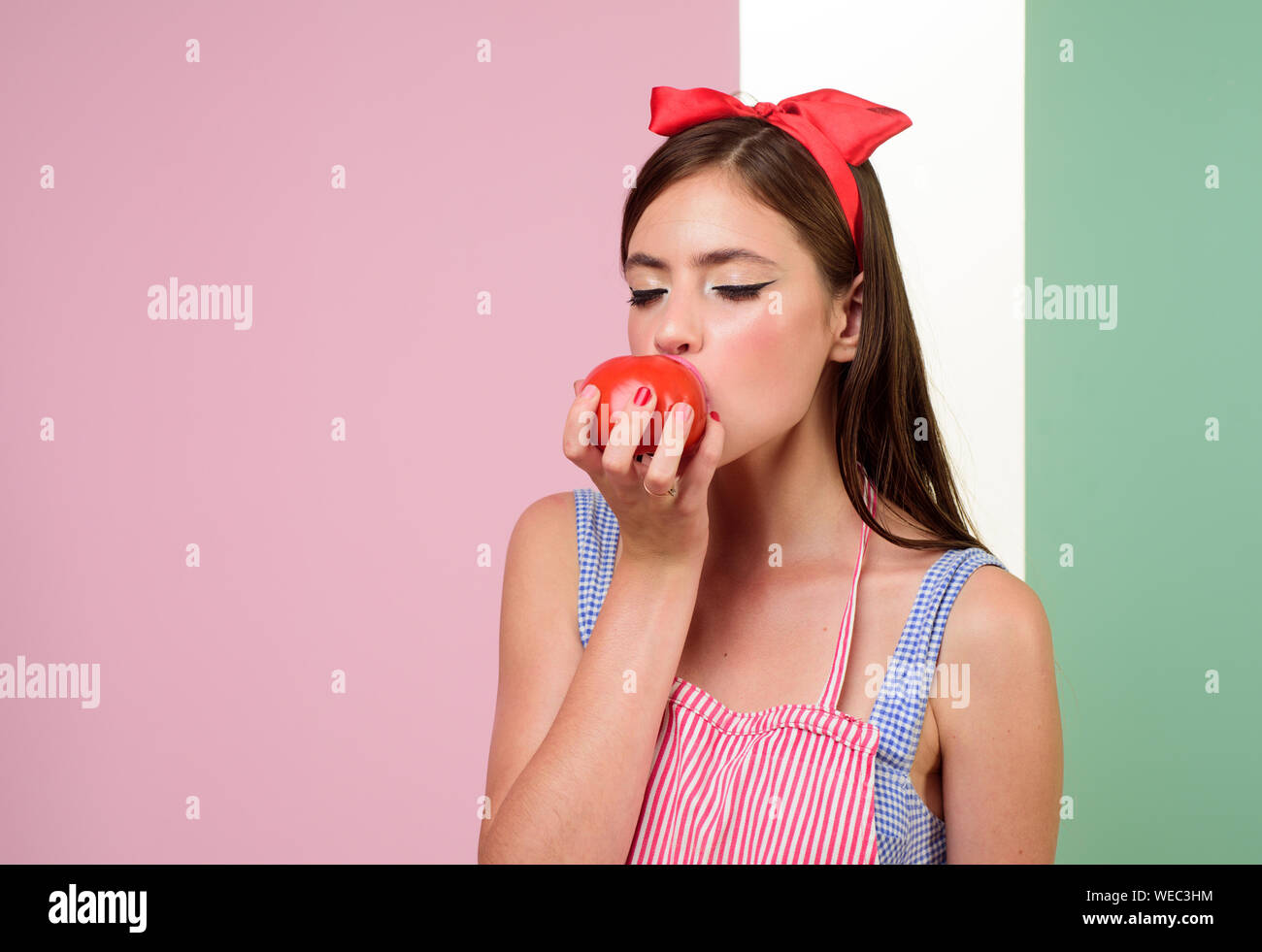 retro woman eating tomato. vegetarian and organic food. pinup girl with ...