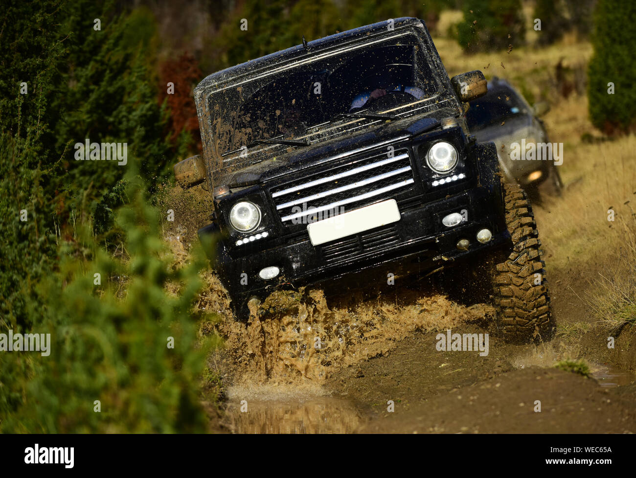 Off road vehicle or SUV crossing puddle with dirt splash. Competition ...