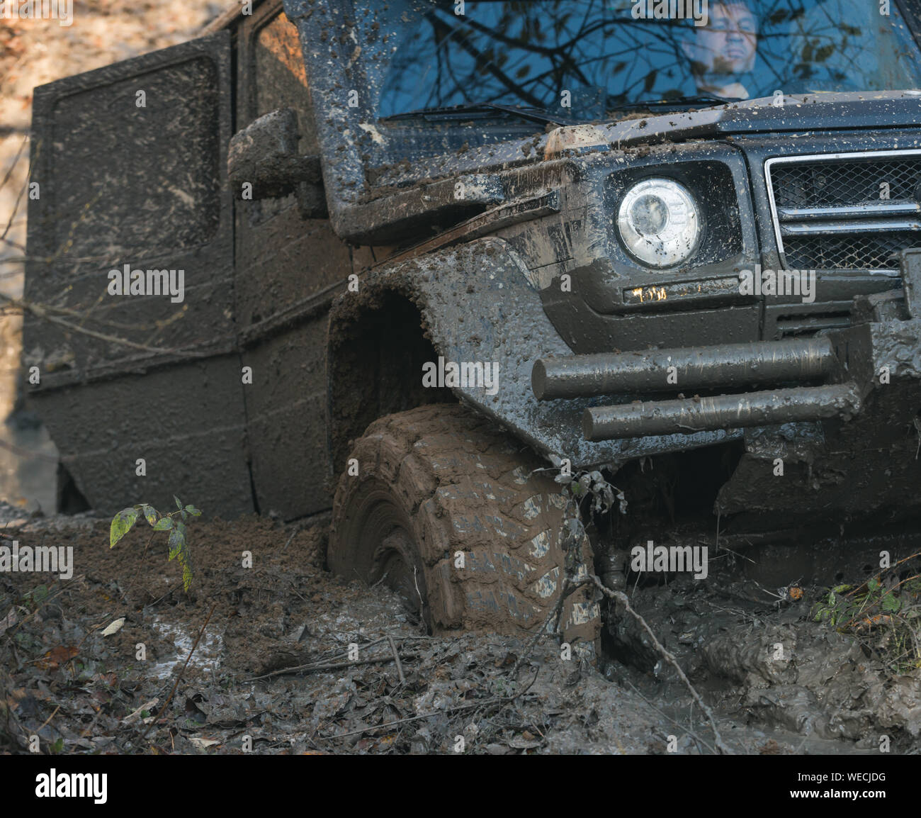 Dirty offroad car with open door stuck in deep rut Stock Photo - Alamy