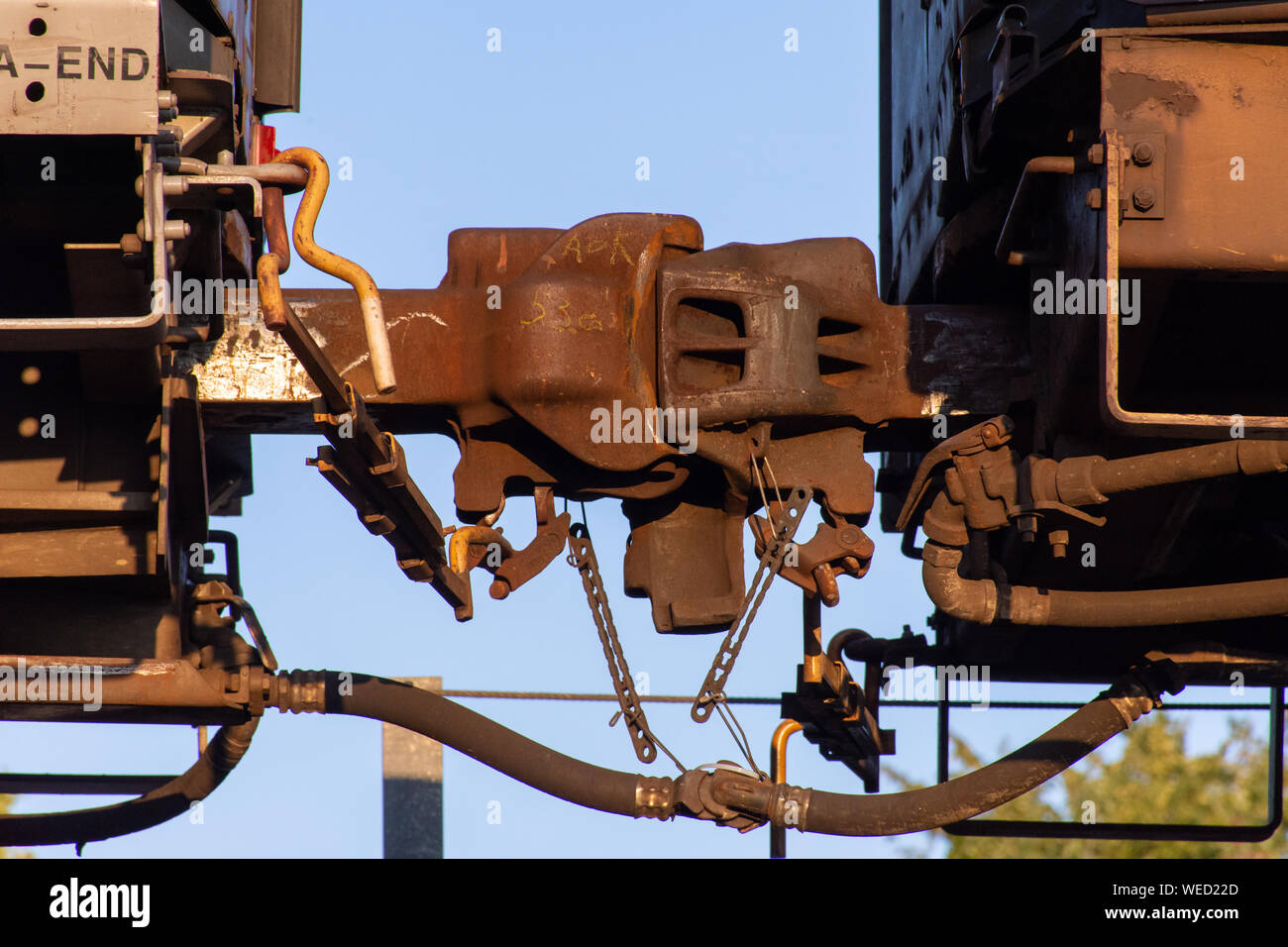 Close up of train joint between cars and break system lines on a train ...