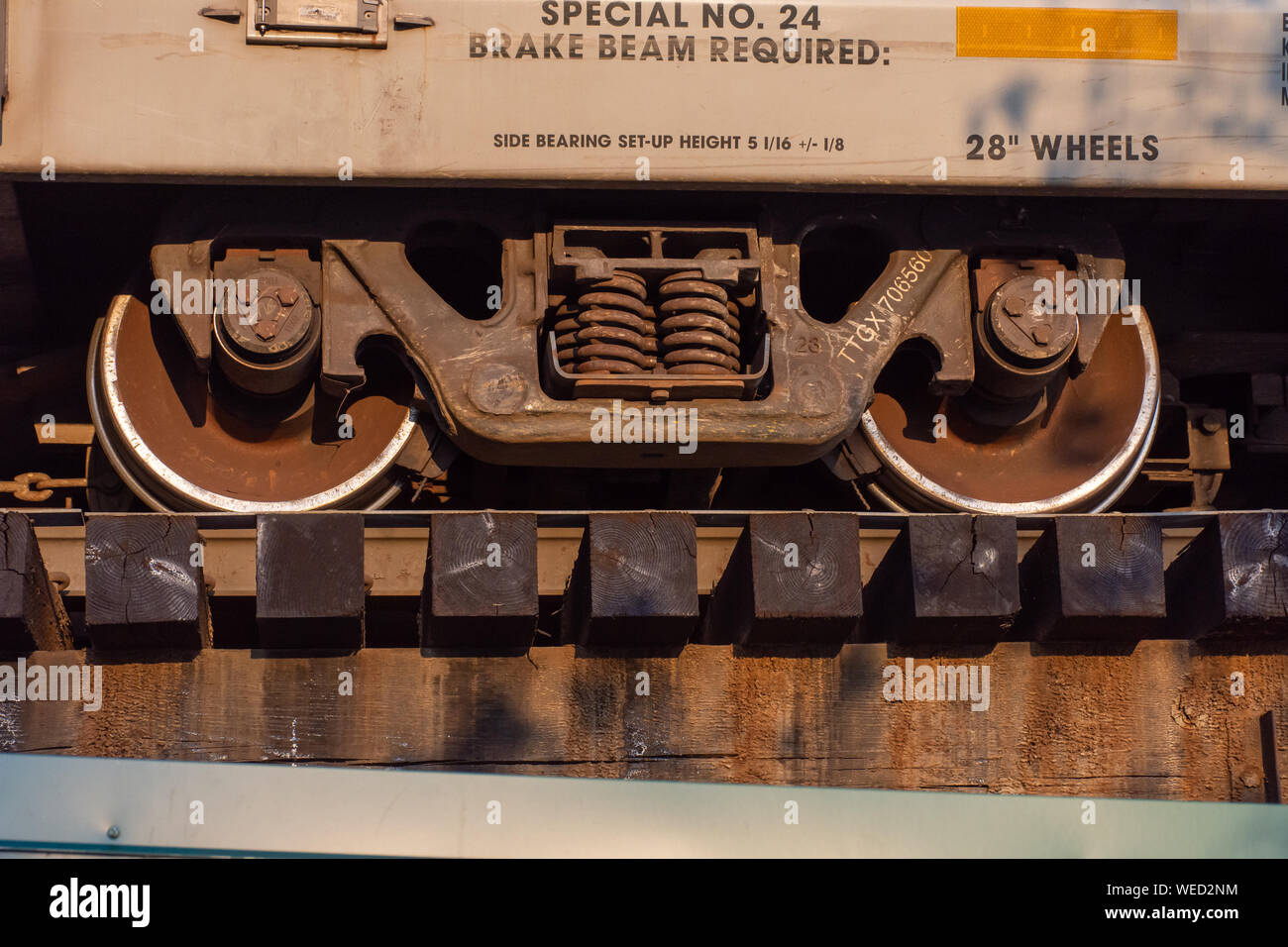 Close up of train wheels and break system in motion on track on wooden ...