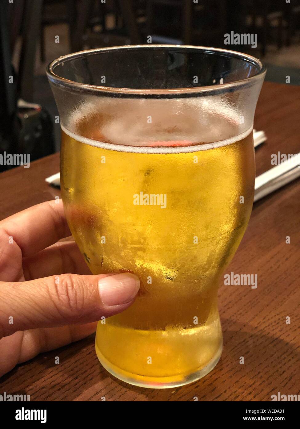 Close up of a cold glass of beer, with a hand holding it Stock Photo ...