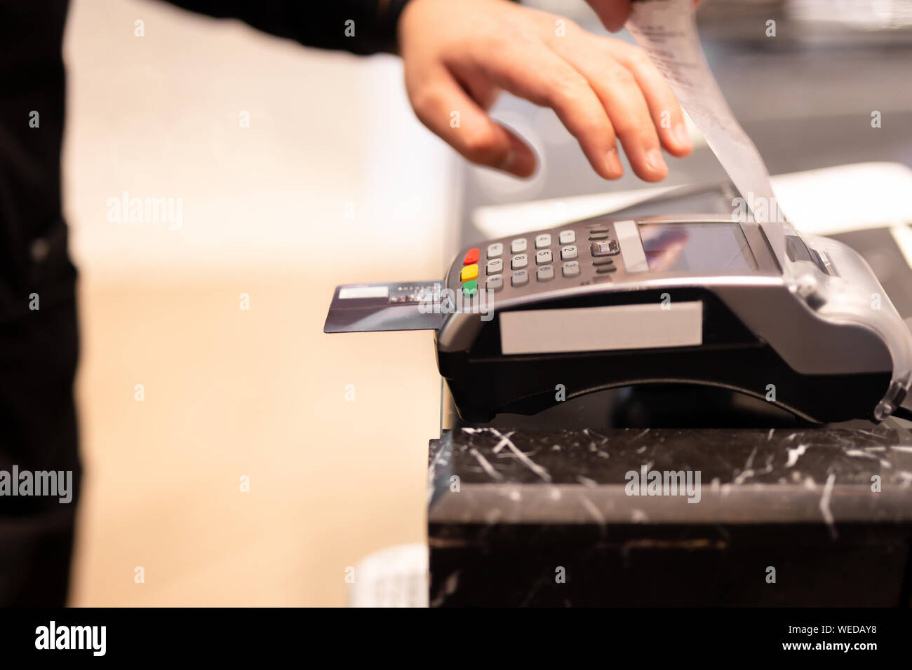Male cashier hand put credit card in cash register for customer payment ...