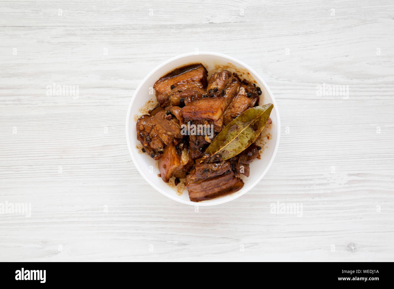 Homemade Filipino Adobo Pork on a white wooden background, top view ...
