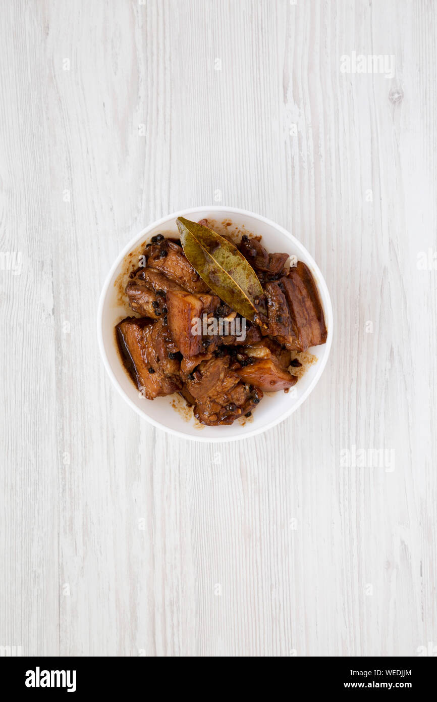 Homemade Filipino Adobo Pork on a white wooden surface, top view. Flat ...