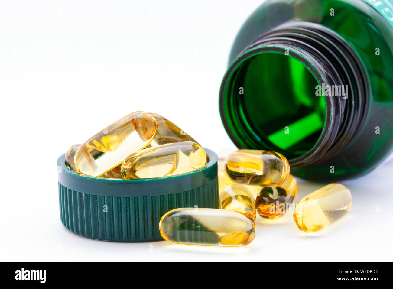 Fish oil capsules and container on white background Stock Photo - Alamy