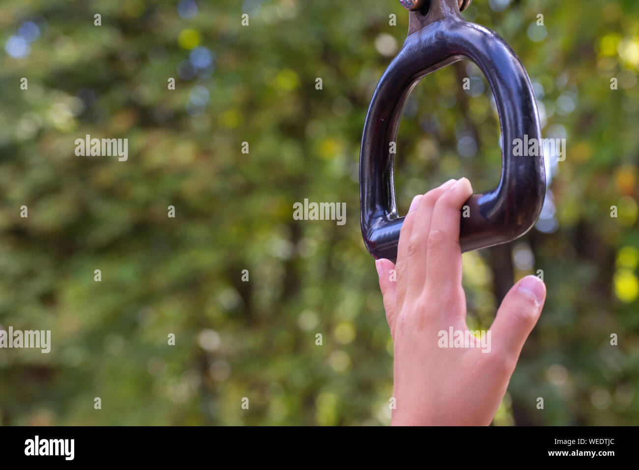 Child's hand nearly achieving goal of grabbing a monkey bar at a ...