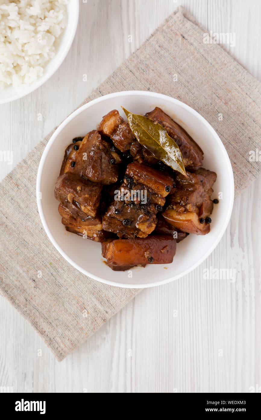 Homemade Filipino Adobo Pork with rice on a white wooden surface, top ...