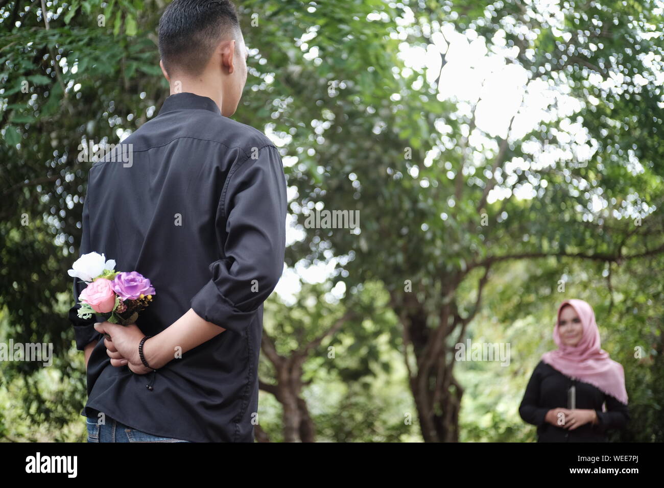 Man hiding flowers hi-res stock photography and images - Alamy