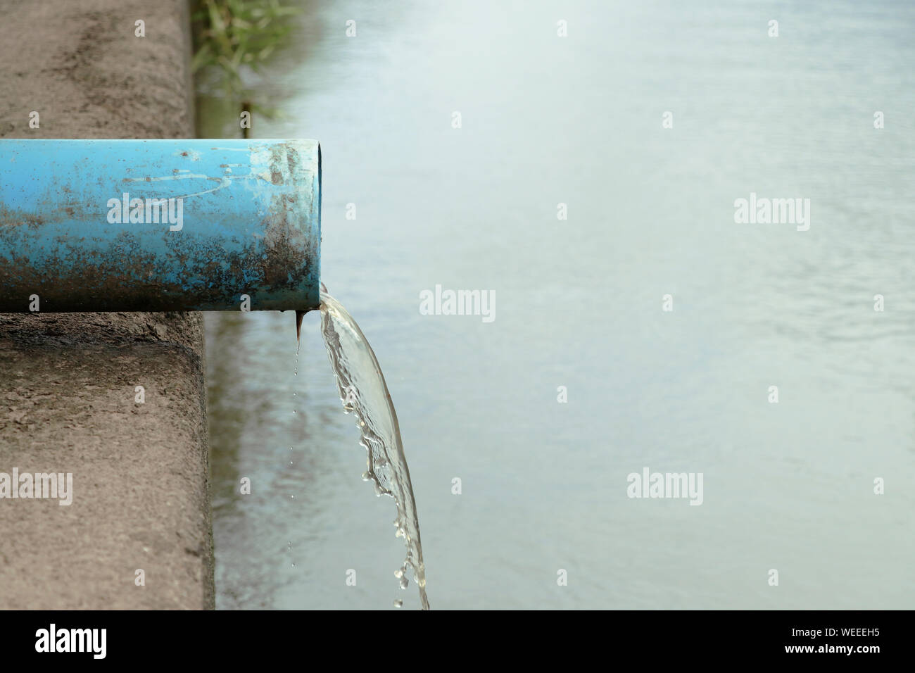 The sewer that water is flowing from the end of the pipe. Water is ...