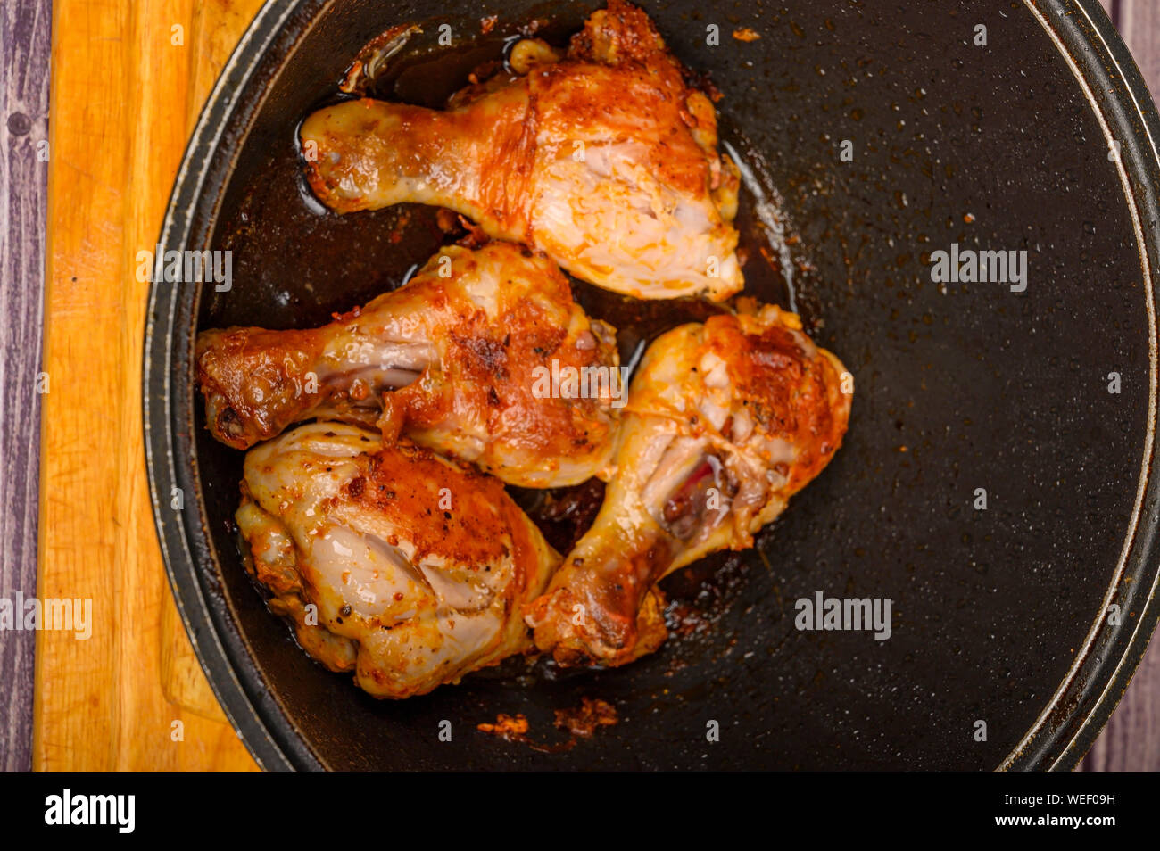 Chicken legs marinated with spices are fried in a cauldron Stock Photo ...