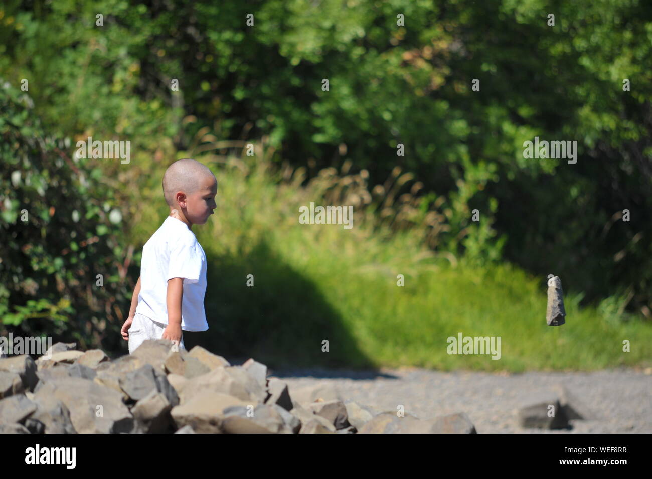 Child throwing stone hi-res stock photography and images - Alamy