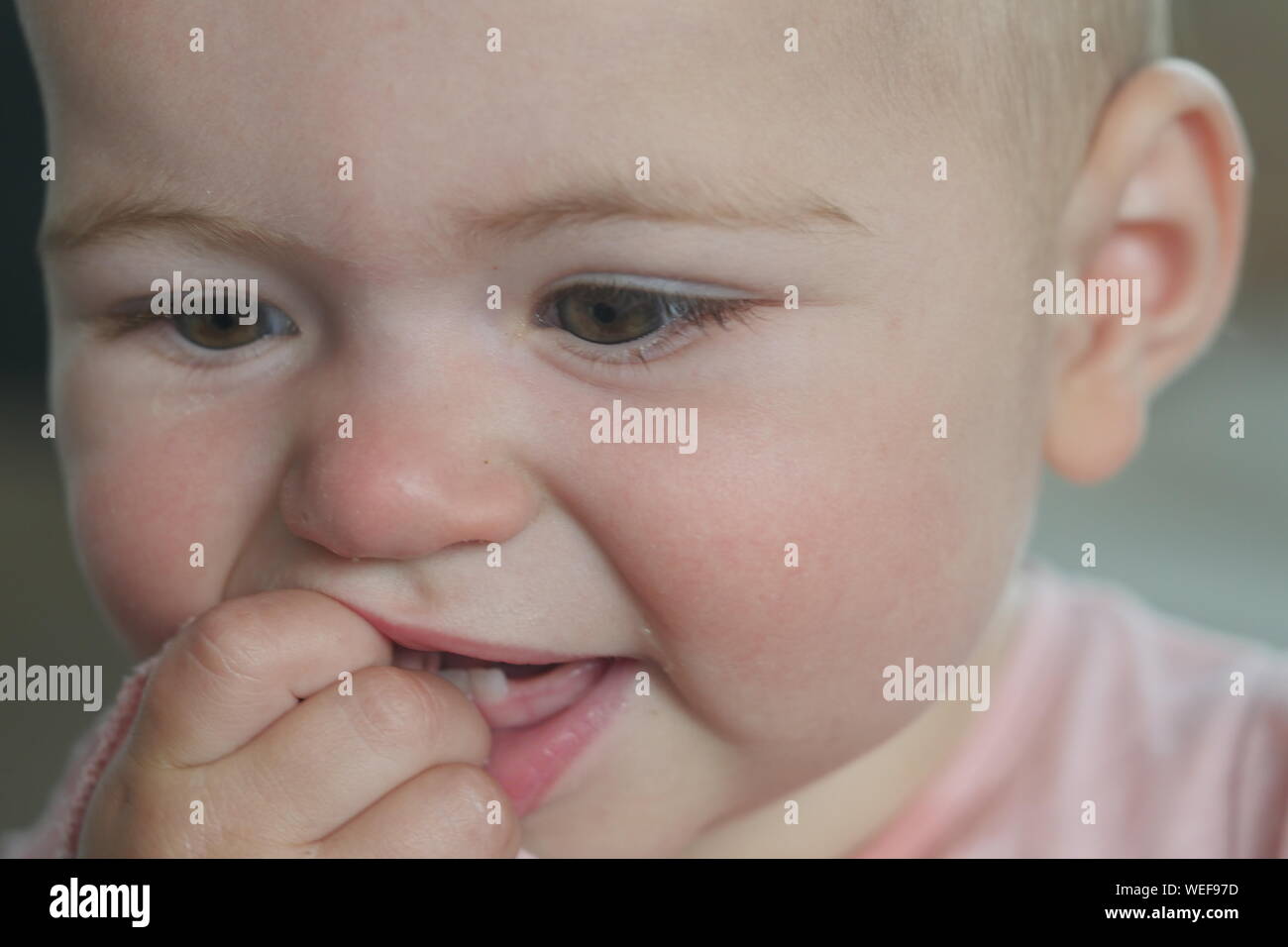 Baby chewing fingers smiling Stock Photo - Alamy