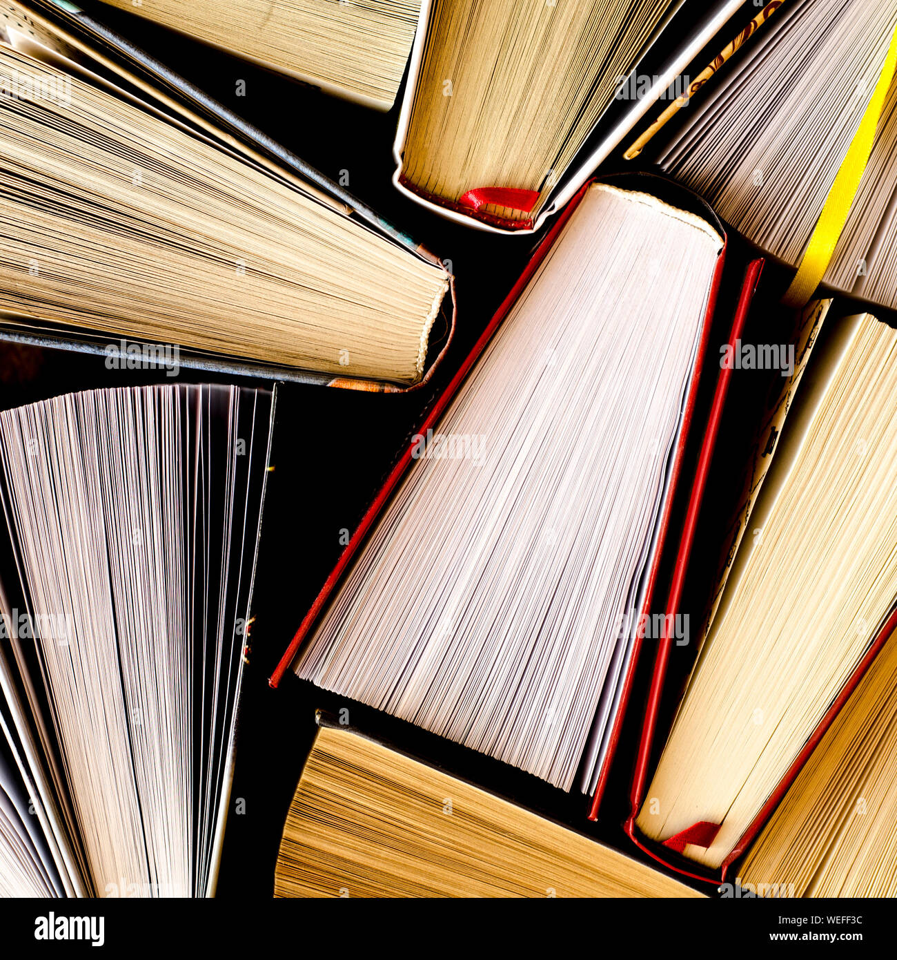 Lots of colourful thick open books stand on a dark background Stock ...