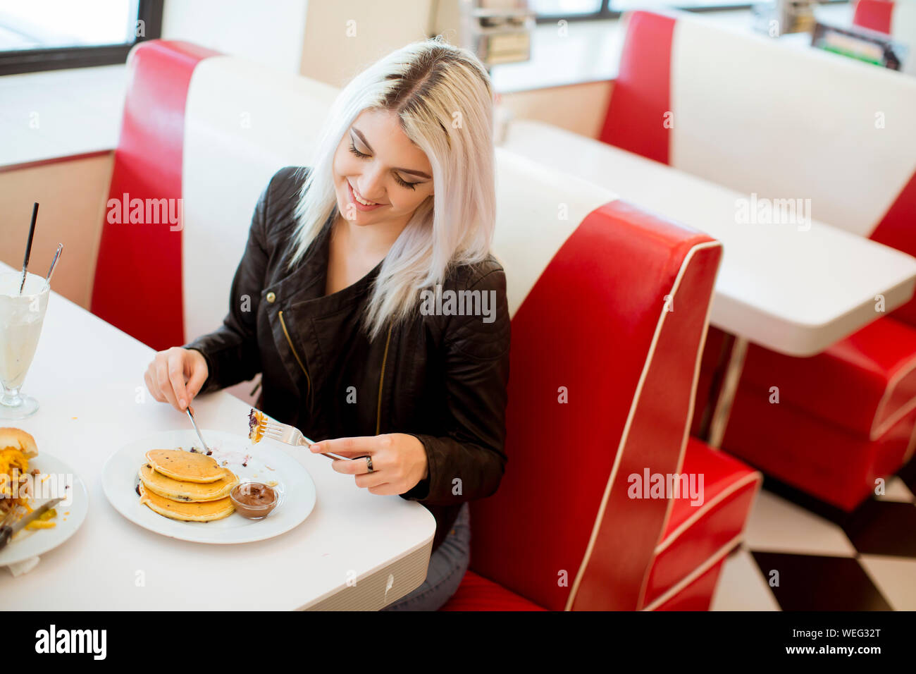 Pretty young woman eating pancakes in the diner Stock Photo - Alamy