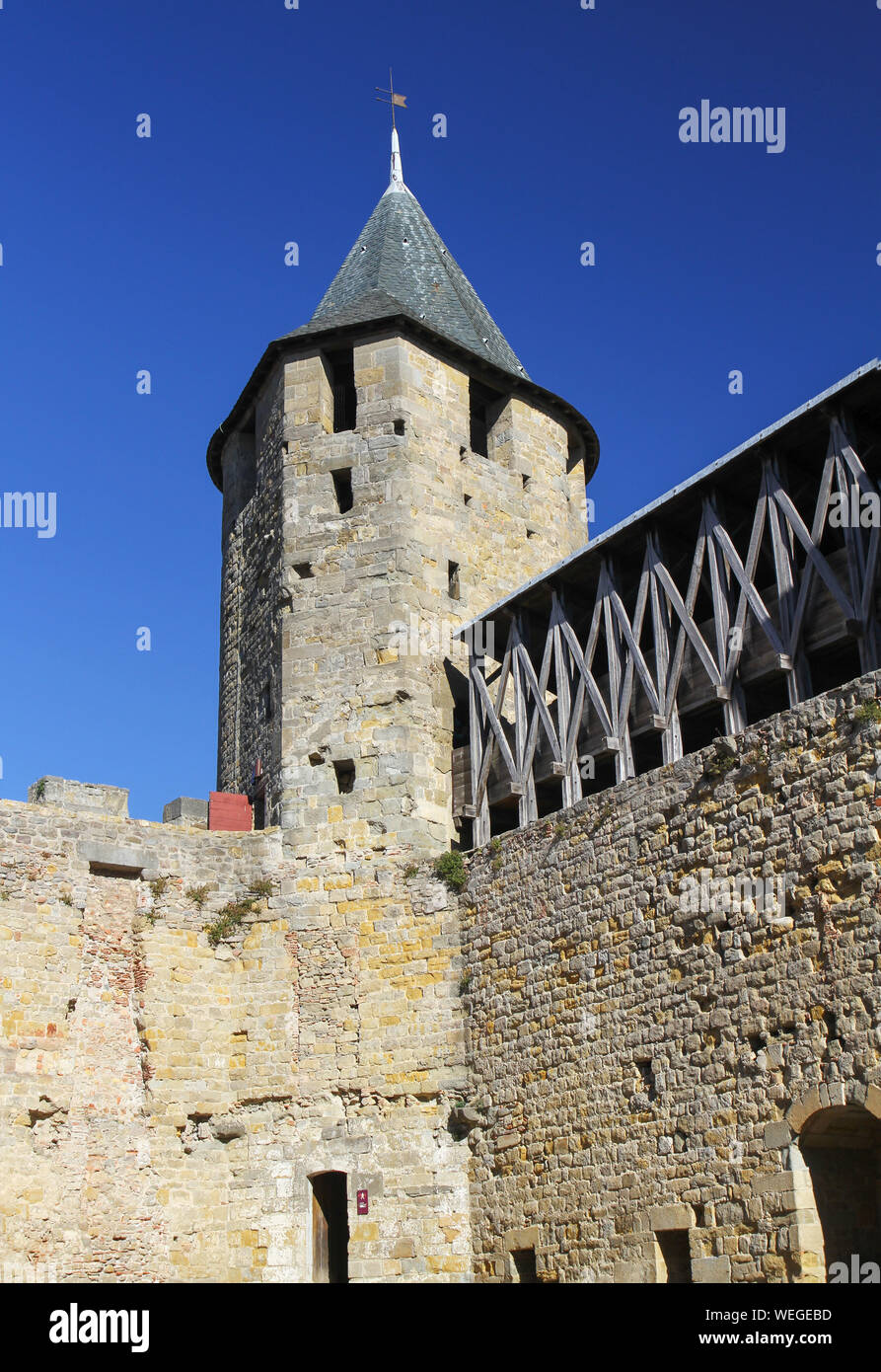 Medieval stone walls with round watchtower against blue sky ...