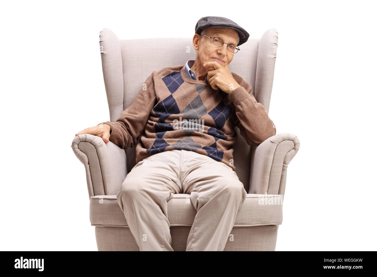 Elderly man sitting in an armchair and thinking isolated on white ...