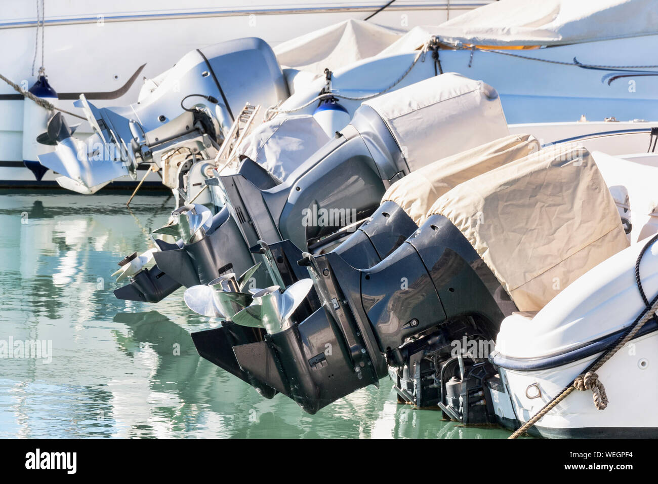 A row of outboard nautical engines mounted on fiberglass boats Stock ...