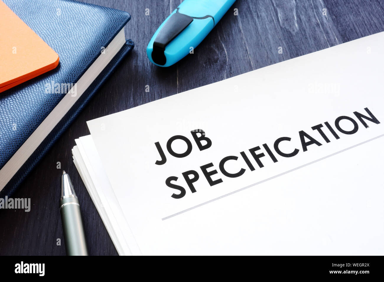 Job specification on the black desk and pen Stock Photo - Alamy