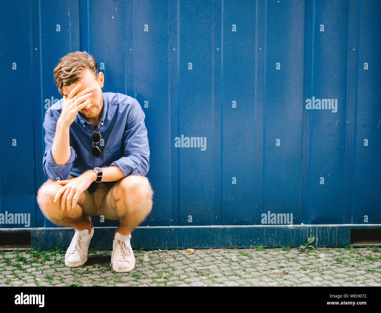Man sitting against wall hands hi-res stock photography and images - Alamy