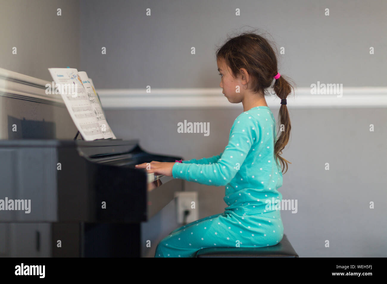Young mixed ethnicity girl practicing piano, San Jose, California Stock ...