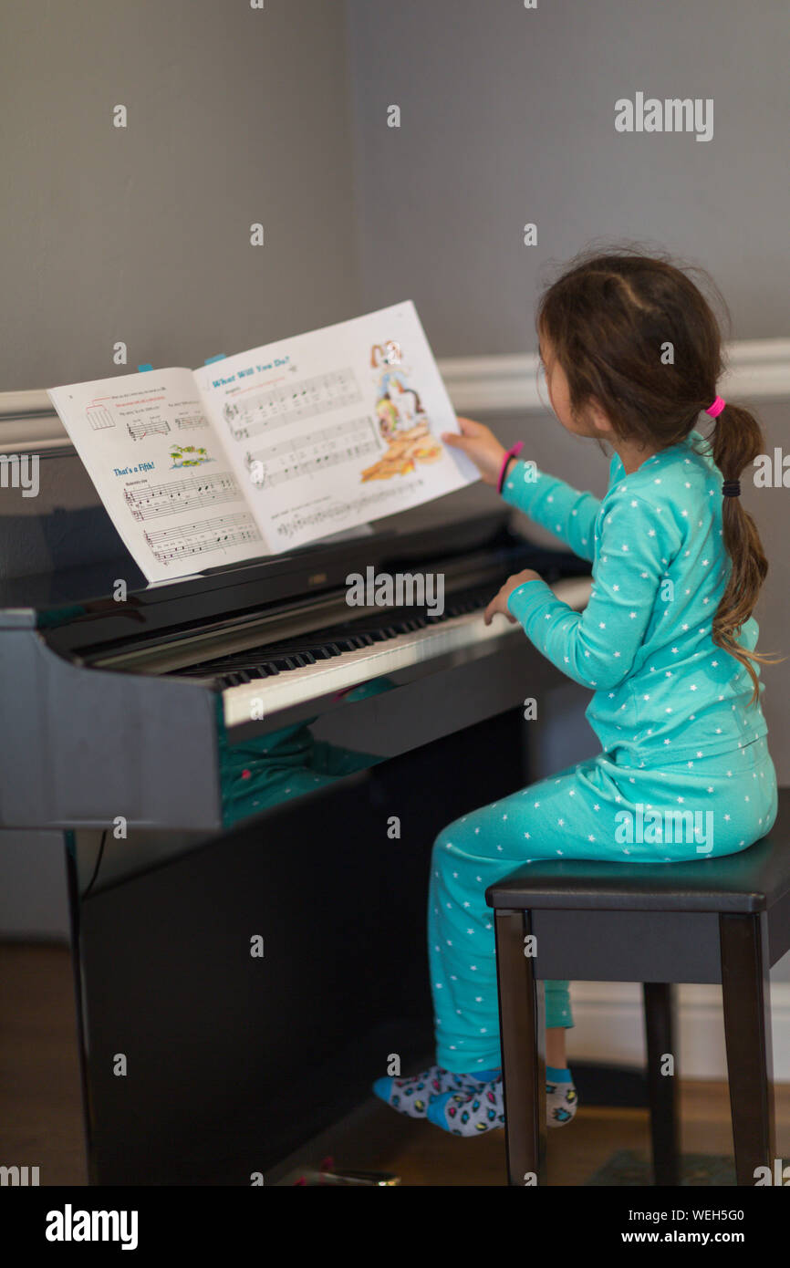 Young mixed ethnicity girl practicing piano, San Jose, California Stock ...
