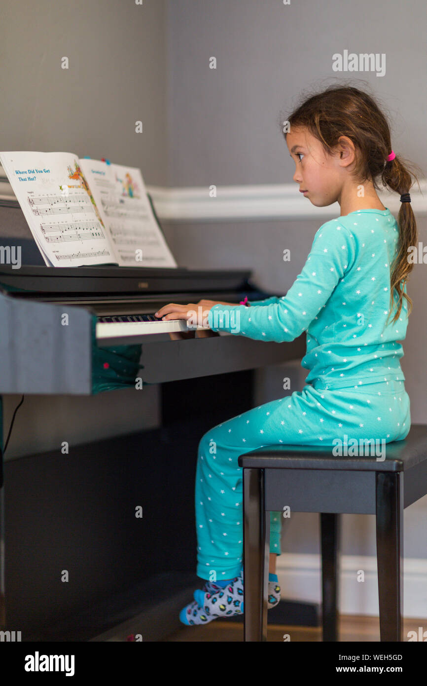 Young mixed ethnicity girl practicing piano, San Jose, California Stock ...
