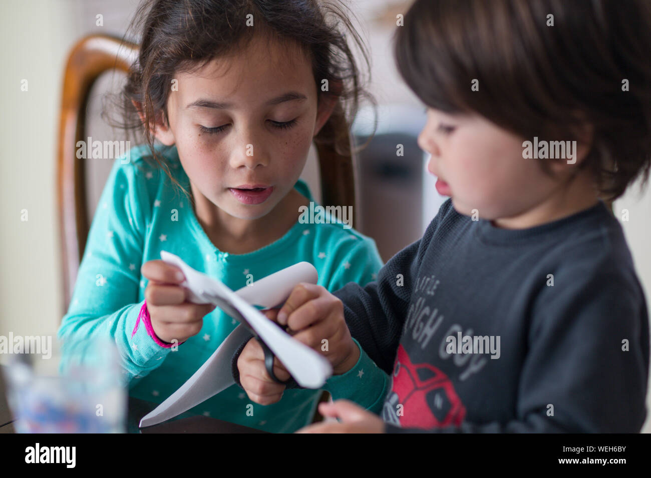 Sister helping younger brother with an arts and crafts project, San ...