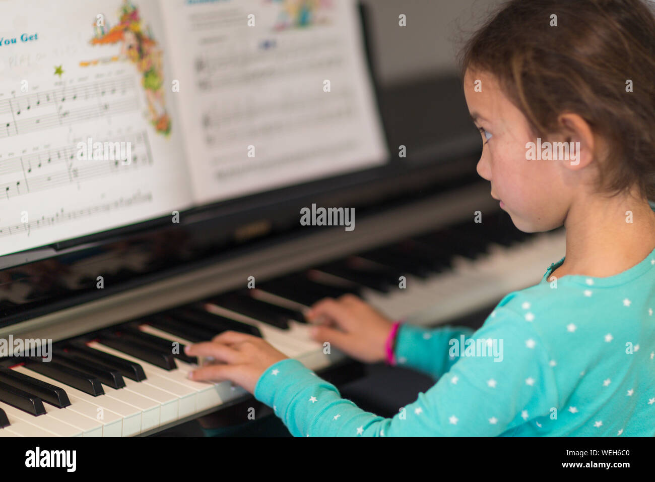 Young mixed ethnicity girl practicing piano, San Jose, California Stock ...