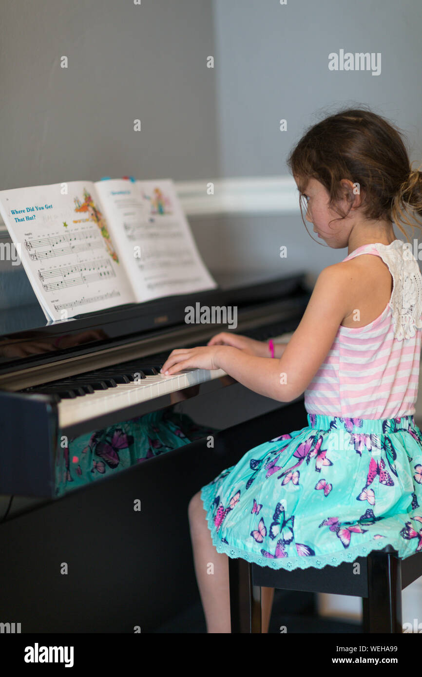 Young mixed ethnicity girl practicing piano, San Jose, California Stock ...