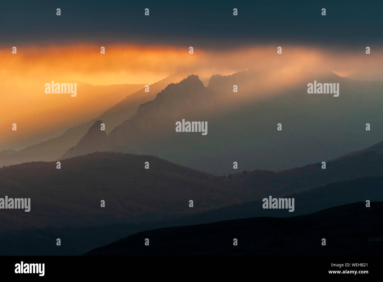 Magic mountain landscape. Sun rays shine through the rain clouds high ...