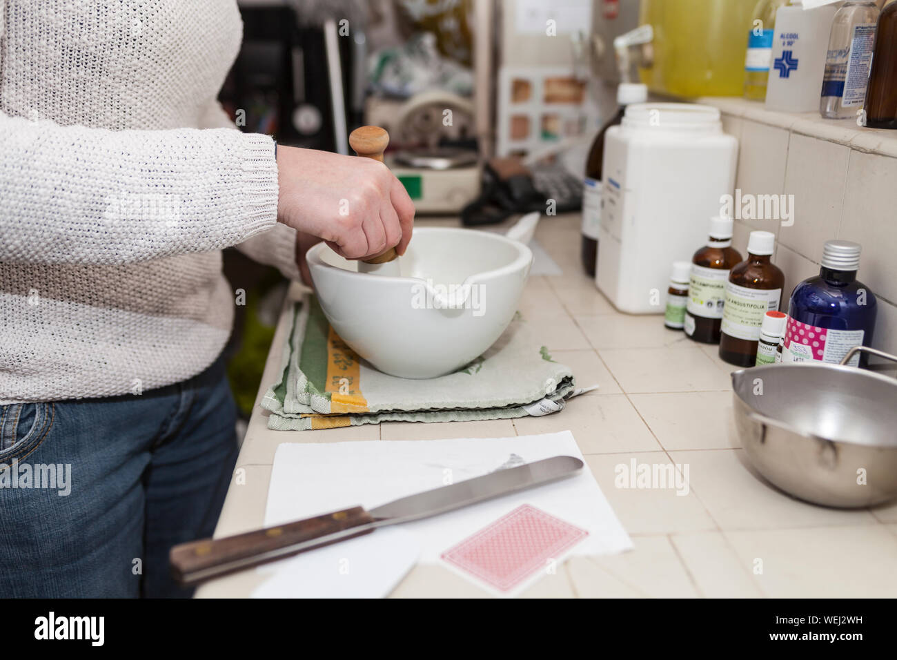 A chemist prepares a powdered medication for feet using a pestle and ...