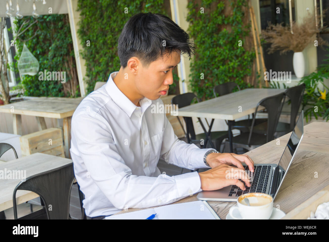 Asian freelancer in white shirt working on laptop Stock Photo - Alamy